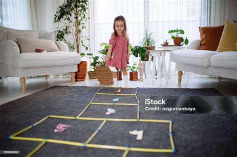 활동적인 귀여운 웃는 유아 소녀 데 재미 점프 집에서 홉 스카치 를 재생 가정 생활에 대한 스톡 사진 및 기타 이미지 가정 생활 개념 거실 Istock