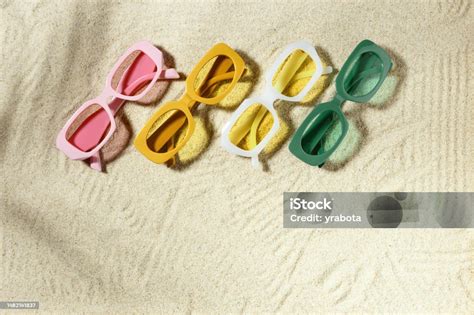 햇빛 야자 그림자에 해변 모래 배경에 화려한 선글라스 세트 컬러 유리가 있는 여름 패션 안경 여름 방학 여름 휴식 개념 미니멀