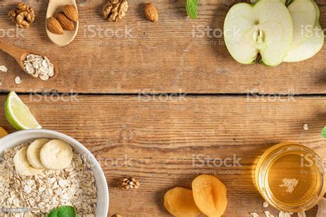 아침 식사 음식 테이블 건강한 아침 식사를 요리하기위한 재료의 프레임 오트밀 건조하고 신선한 과일 꿀과 견과류를 나무 테이블