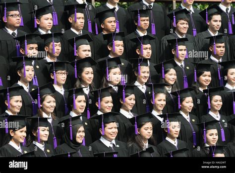 Crowd Of Student Graduate Class In Caps And Gowns Standing In