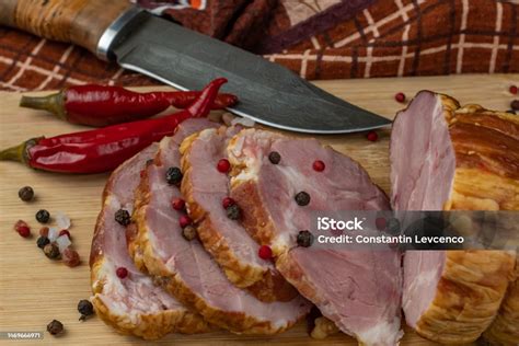 육즙이 많고 맛있는 베이컨 조각은 조각 칼 멀티 컬러 딸기 완두콩 붉은 고추 파슬리 딜 및 바질로 나무 도마에 맛있는 조각으로