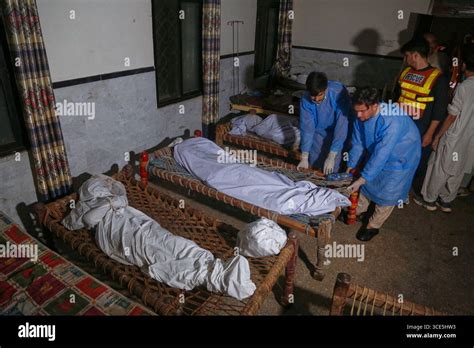 Paramedics Arrange Bodies Of The Victims Of Flash Flooding At A Local Hospital In Pir Baba In