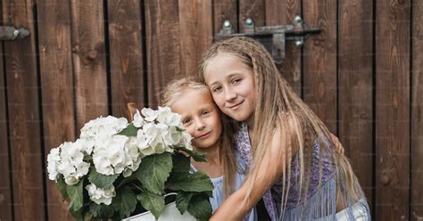 Sœurs De Petites Filles Souriantes Heureuses Sur Fond De Mur De Grange