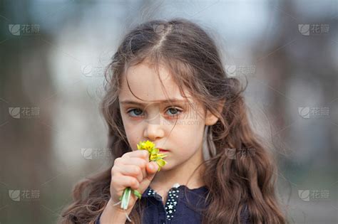 一个6岁小女孩闻花的肖像