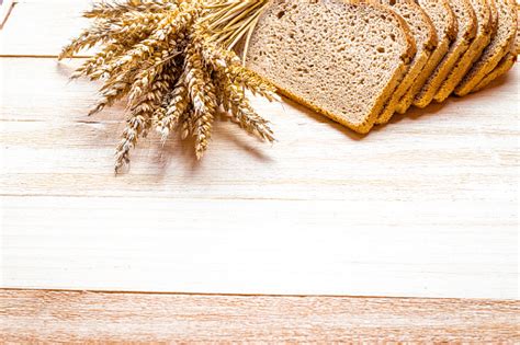 소박한 호밀 나무 질감 배경에 밀 곡물 귀 또는 스파이크 식물 소박한 전통 빵의 신선한 덩어리 바삭바삭한 빵집과 부스러기가 있는 빵집 베이커리 제품 라벨용 디자인 요소