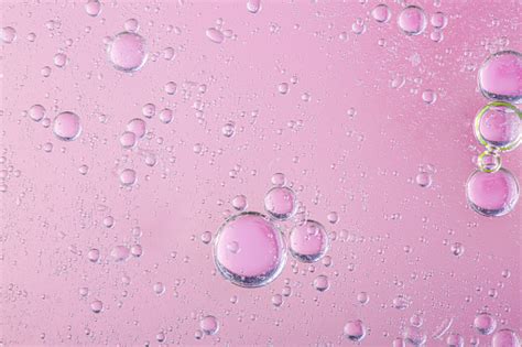 산호 배경에 거품이있는 오일 핑크 추상 공간 배경 부드러운 선택적 초점 물 표면에 기름의 매크로 가해집니다 복사 공간을