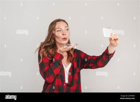 Freestyle Young Woman With Freckles Standing Isolated On Grey Taking