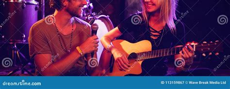 Male And Female Performers Sitting On Stage In Illuminated Nightclub
