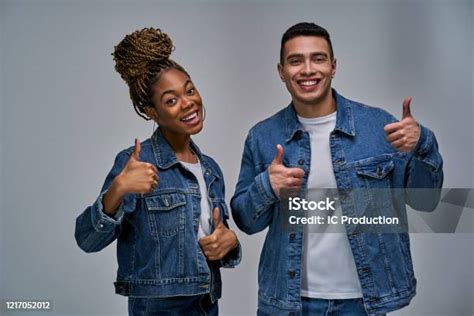 데님 재킷을 입은 여자와 웃고 손과 손가락을 들고 서있는 남자는 같은 상징을 보여줍니다 감정 개념 2명에 대한 스톡 사진 및 기타 이미지 Istock