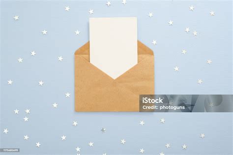 색종이 스타로 장식 파스텔 블루 배경에 크래프트 종이 봉투에 빈 카드 크리스마스 새해 겨울 휴가 초대 모형 0명에 대한 스톡