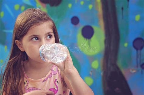 La Belle Petite Fille Boit L Eau De La Bouteille En Plastique Image