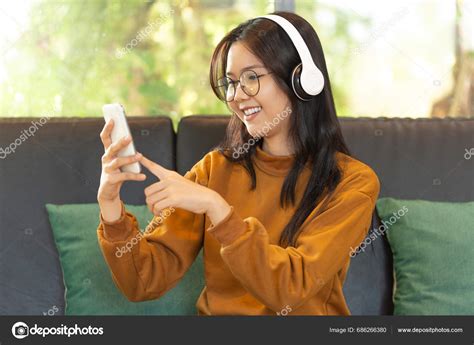 Asian Woman Wearing White Wireless Headphones Listening Music Using