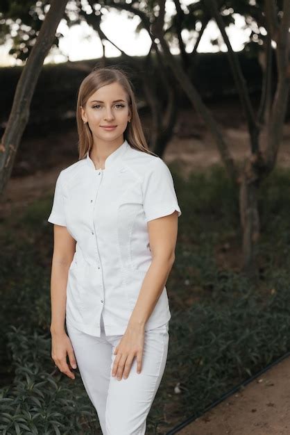 Premium Photo A Woman In A White Uniform Stands In Front Of A Tree And Wears A White Shirt