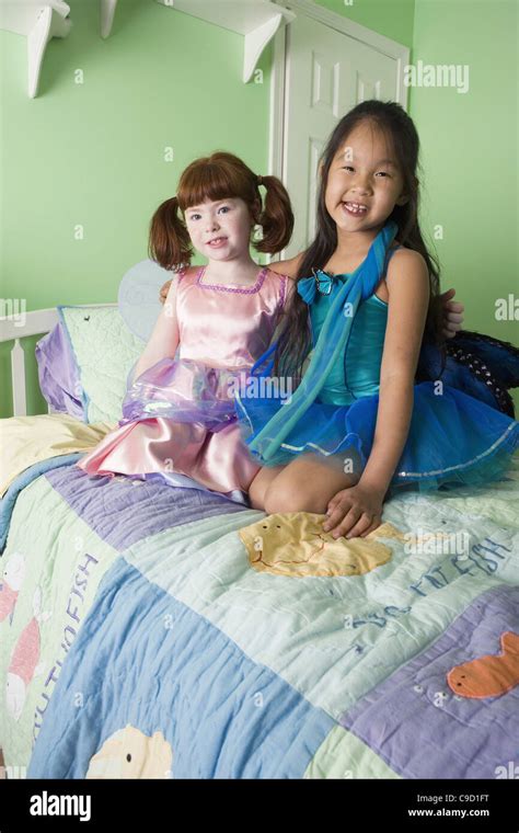 Zwei Junge Asiatinnen In Kost Men Auf Bett Sitzend Stockfotografie Alamy