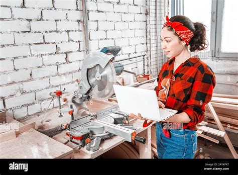 A Woman With A Laptop Sets Up With Special Software Industrial Machines With Digital Control In