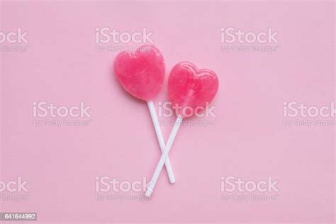 빈 파스텔 핑크 종이 배경에 두 핑크 발렌타인 데이 하트 모양 롤리팝 사탕 사랑 개념 상단 보기 미니멀리즘 컬러풀힙스터 스타일