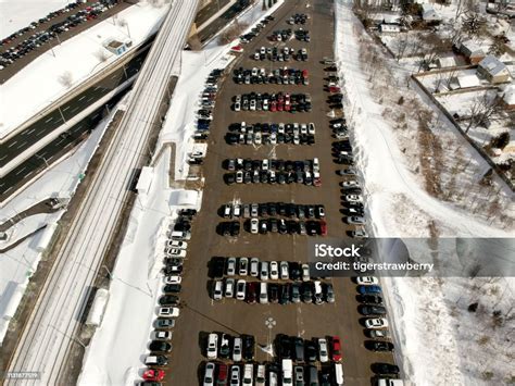 겨울에 통근 열차 근처에 자동차가 가득 주차장 공중 보기 겨울철에는 주차장에 차량이 걸려 있습니다 이 도시에 기차를 여행 하는 자동차를 떠나는 시민 겨울에 대한 스톡 사진