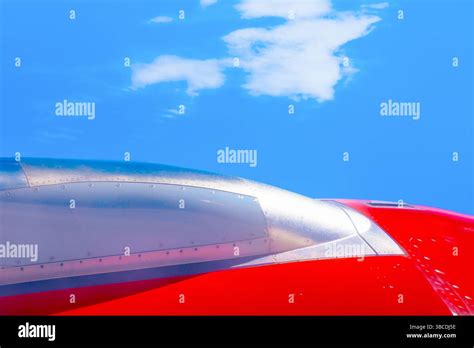 Shiny Aircraft Surface Likely Fuselage In Flight With A Vibrant Red Section Visible Below