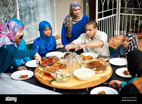 Dig In Everyone Shot Of A Muslim Family Eating Together Stock Photo Alamy