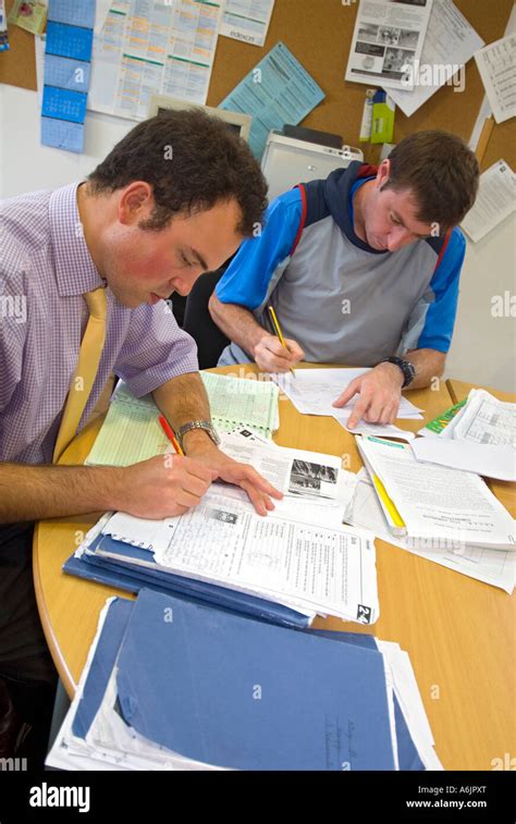 Teachers Marking Papers In School Assessing And Marking Students