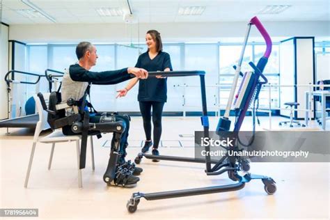 기계식 외골격 물리 치료 보조원이 로봇 골격으로 장애인을 들어 올려 일어납니다 미래형 재활 현대식 병원의 물리치료 건강관리와 의술에 대한 스톡 사진 및 기타 이미지 Istock