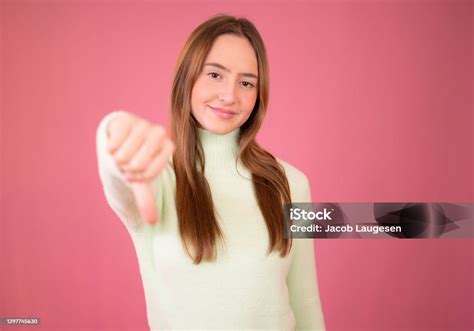 핑크 배경 위에 엄지 손가락 아래로 제스처와 긴 머리와 아름다운 소녀 사람들에 대한 스톡 사진 및 기타 이미지 사람들 한