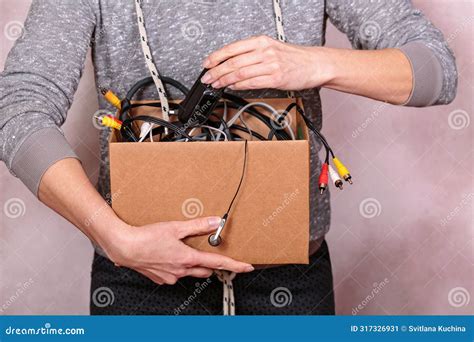 Hands Of Woman Sorting Through Electronic Cables And Gadgets Stock