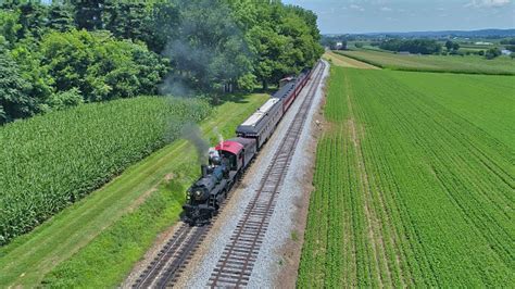 작은 철도 도로 역에서 증기를 뿜어내며 복원된 골동품 증기 엔진과 승용차의 공중 보기 로드고잉 증기 기관에 대한 스톡 사진 및 기타 이미지 로드고잉 증기 기관 증기