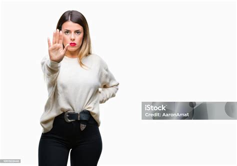 아름 다운 젊은 여자는 손의 종 려를 가진 정지 노래를 하 고 격리 된 배경 위에 캐주얼 백색 스웨터 얼굴에 부정적이 고 심각한 제스처와 경고 식입니다 T 셔츠에 대한 스톡