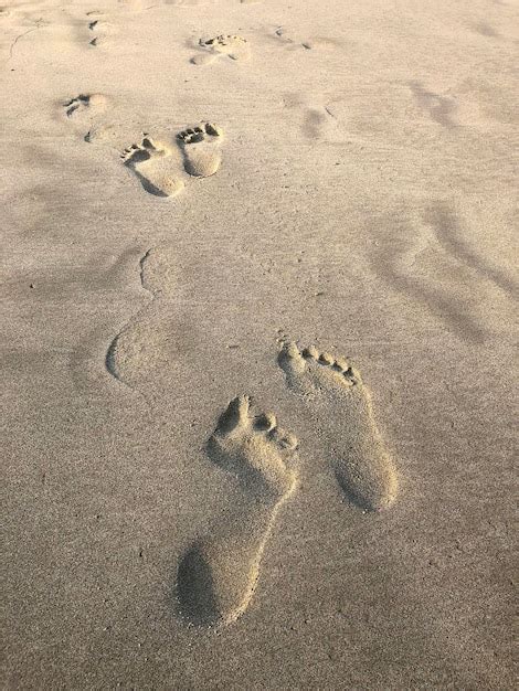 모래 해변 배경에 두 발자국 프리미엄 사진