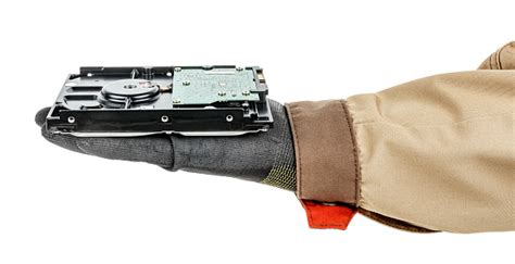 컴퓨터 하드 드라이브는 흰색 배경에 고립 된 검은 색 보호 장갑과 갈색 유니폼을 입은 사람의 손바닥에 있습니다 It 지원에 대한 스톡 사진 및 기타 이미지 Istock