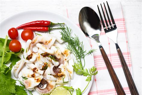 식탁 꼭대기 보기에 레몬 허브와 향신료와 오징어 샐러드 촉수 문어 요리 전채 음식 뜨겁고 매운 칠리 소스 해산물 흰 접시에 제공 고기에 대한 스톡 사진 및 기타 이미지