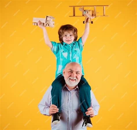 Premium Photo Young Grandson And Old Grandfather With Toy Plane And