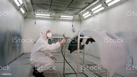 자동차 페인트를 이전처럼 아름답게 수리할 수 있는 최고의 차고의 표준 보호용 Ppe 슈트의 백인 자동차 페인트 전문가 전문적인 의도로 새 차를 칠하기 위해 공기를 분사합니다