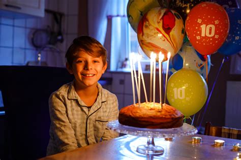 사랑스러운 행복 금발의 작은 아이 소년은 자신의 생일을 축하합니다 집에서 만든 구운 케이크에 촛불을 부는 아이 실내 학교 어린이