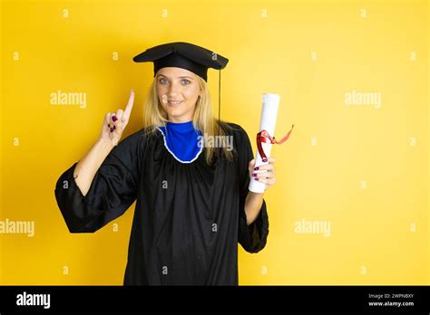 Beautiful Blonde Young Woman Wearing Graduation Cap And Ceremony Robe