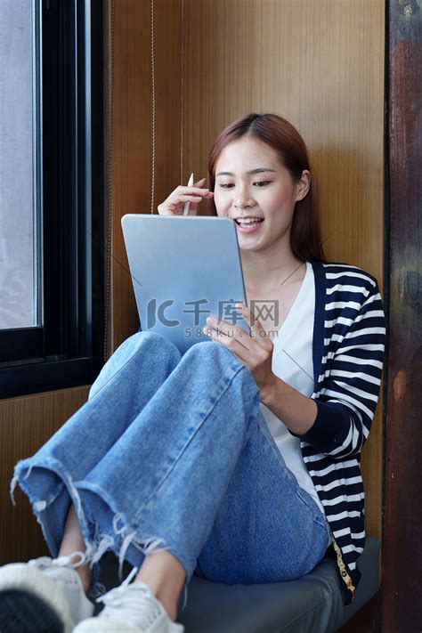 一位微笑的亚洲少女使用平板电脑通过视频会议在线学习的肖像高清摄影大图 千库网