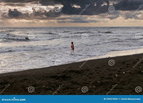 A Woman Walks Into Stormy Waves Dangerous For Swimming View In The