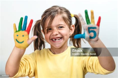 손에 그려진 다섯 숫자와 행복 한 이빨 없는 어린 소녀 웃고 재미 웃는 얼굴과 숫자로 그녀의 손을 그리는 어린 소녀 숫자 5 및