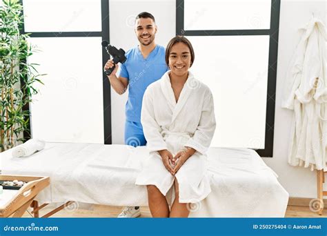 Latin Man And Woman Wearing Physiotherapy Uniform Holding Percussion