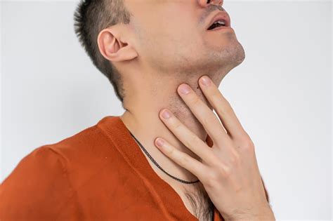 사람 의료 및 문제 개념 불행한 남자가 그의 목을 만지고 회색 배경을 통해 목 구멍 통증으로 고통 목 통증에 대한 스톡 사진 및