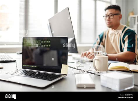 Background Image Of Laptop With Green Code Lines On Screen In It Developers Office With Person