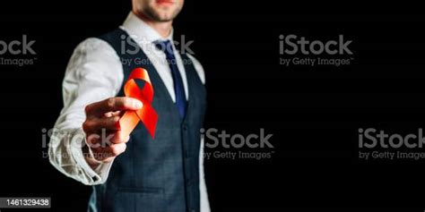 Hiv 에이즈 어두운 배경에 고립 된 Hiv 세계 의 날에 빨간 리본 인식 보조 제와 암 기호를 들고 남자 건강 의료 표지판