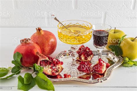 잘 익은 석류와 사과 와인 한 잔 꿀 한 그릇이 있는 아름다운 정물 흰색 배경입니다 로쉬 하샤나의 개념 개념에 대한 스톡 사진