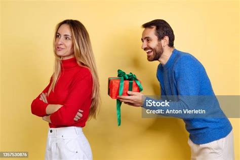 쾌활한 부부의 자른 초상화 남자는 그의 여자 친구에게 노란색 배경에 고립 된 크리스마스 선물을주는 겨울 방학 2명에 대한 스톡 사진 및 기타 이미지 Istock