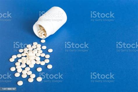 약병과 흰 알약이 밝은 배경에 쏟아졌습니다 의약품 및 처방약 플랫 누워 배경 마약 병에서 쏟아지는 하얀 의료용 알약과 정제 0