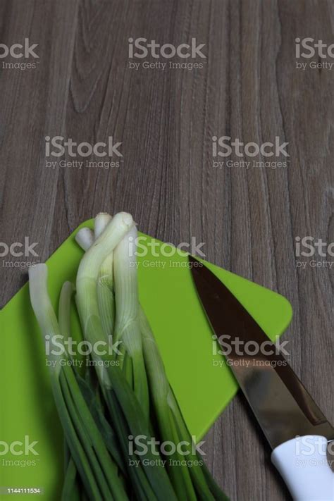 테이블 위에 신선한 채소 들이 깔끔하게 배치 되었습니다 향기로운 양파 부엌 칼과 커팅 보드 옆에 있습니다 건강 한 샐러드를 위한