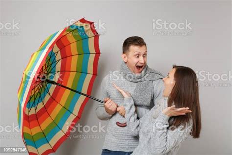 회색 벽 배경 스튜디오 초상화에 고립 된 우산 아래 함께 회색 스웨터 스카프에 커플 여자 사람입니다 건강 한 생활 습관 병 아픈 질병 치료 추운 계절 개념 복사 공간을 모의