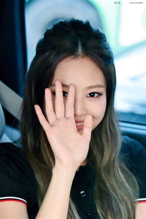 A Woman Sitting In A Car Holding Her Hand Up To Her Face With Both Hands