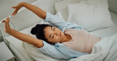 젊은 웃는 아시아 여자는 아침에 일어나 침대에서 몸을 뻗는다 사진 Unsplash의 사람 이미지